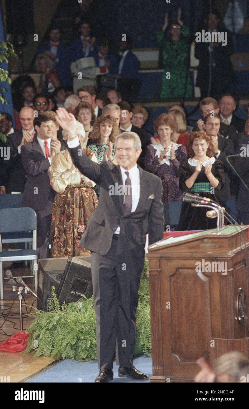 Pat Robertson waves to an audience as unidentified family members look ...