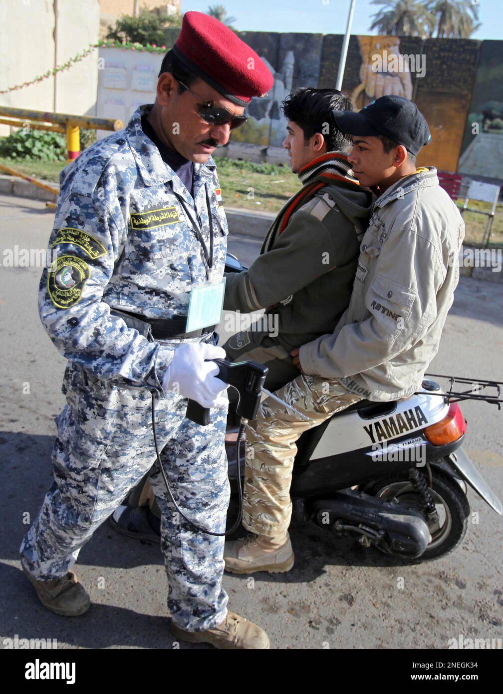 An Iraqi police officer uses a scanner device to inspect a motorcycle ...
