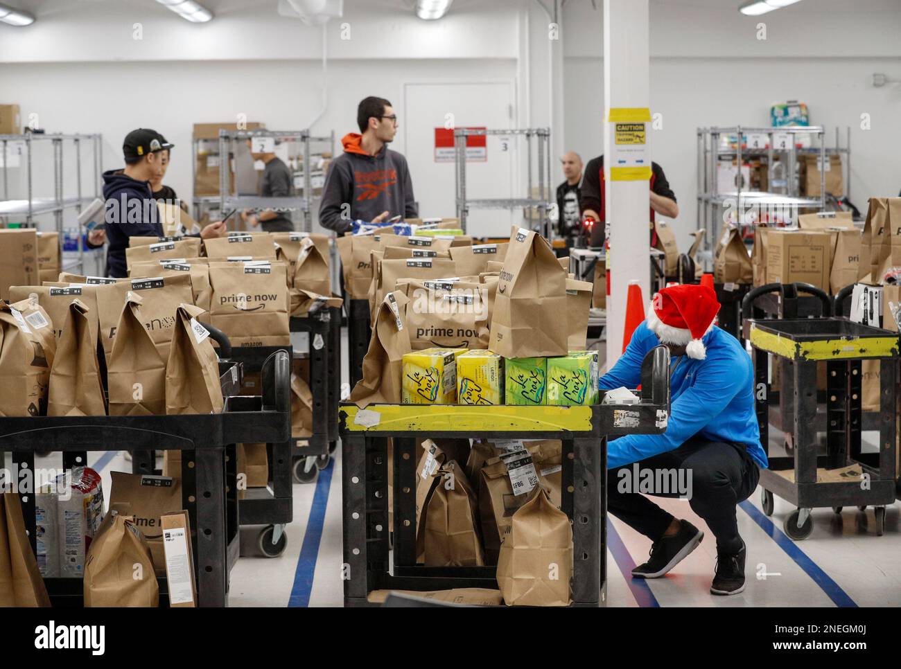 Associates loads carts with orders that are set for delivery at the ...