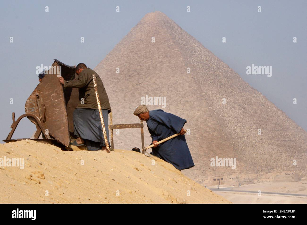 Egyptian archaeology workers ferrying sand in trolleys on rail tracks ...