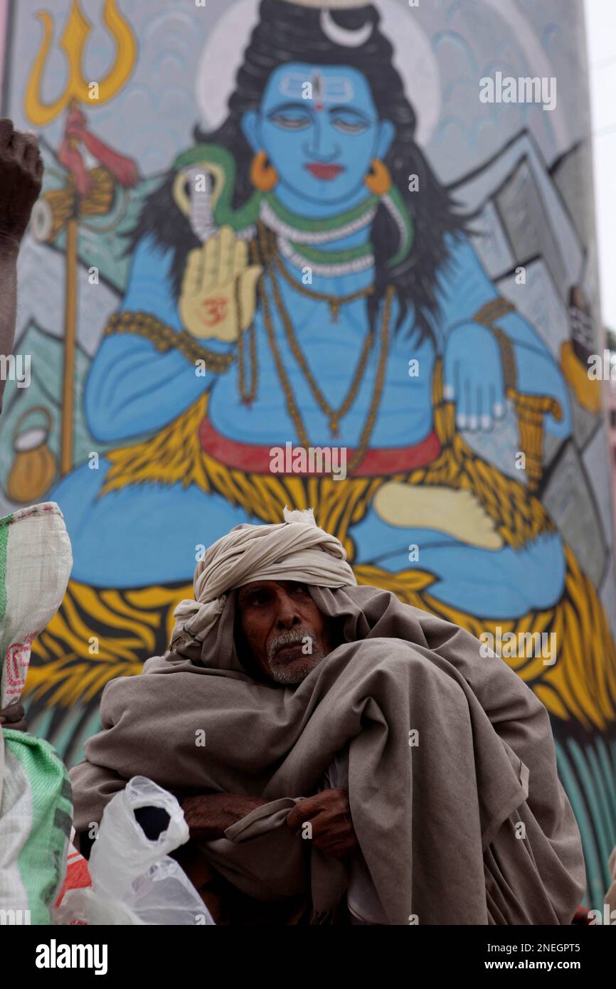 A Hindu devotee is seen wrapped in woolens on a cold morning in ...