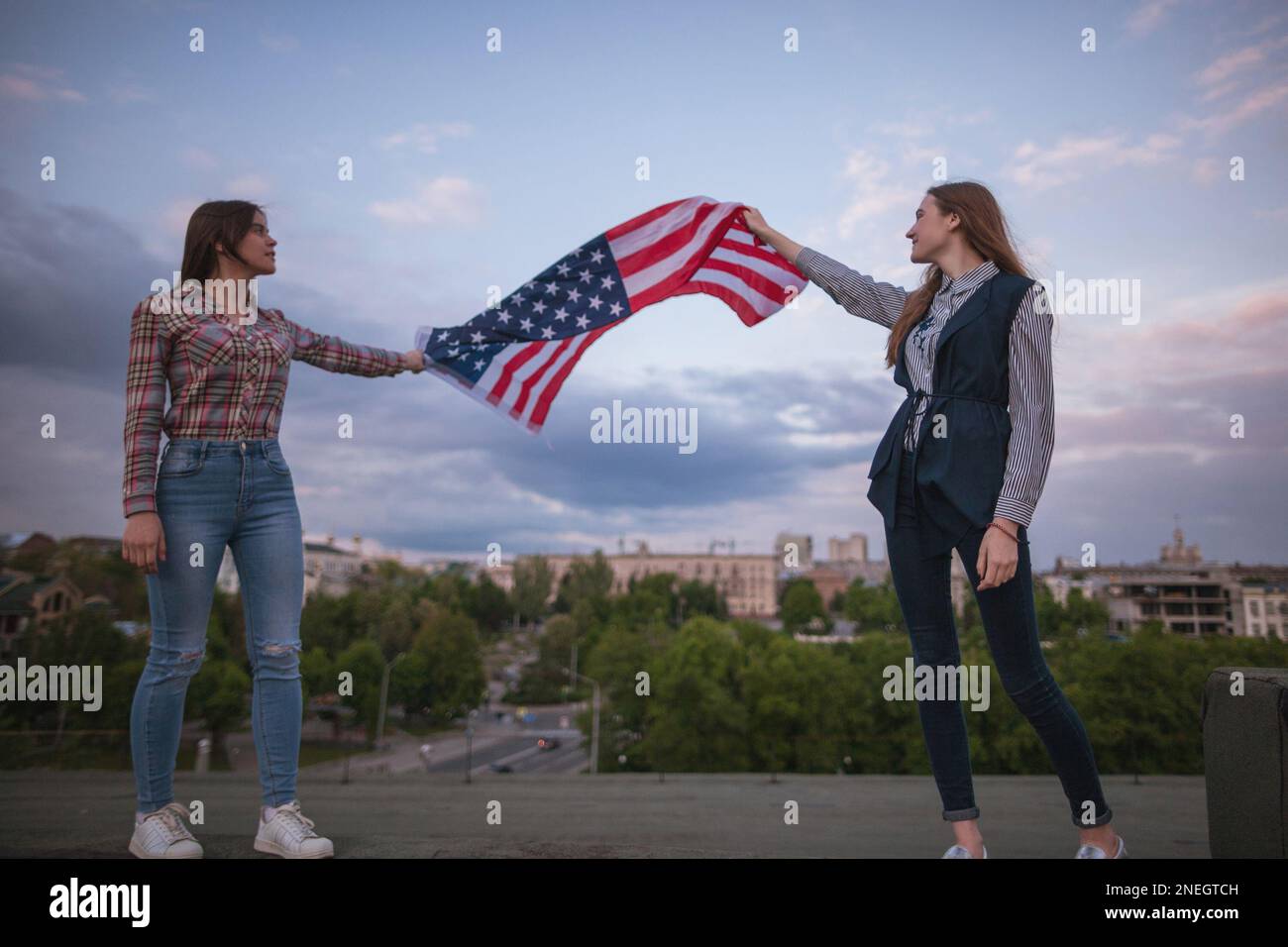 Two students holds flying american flag Stock Photo - Alamy