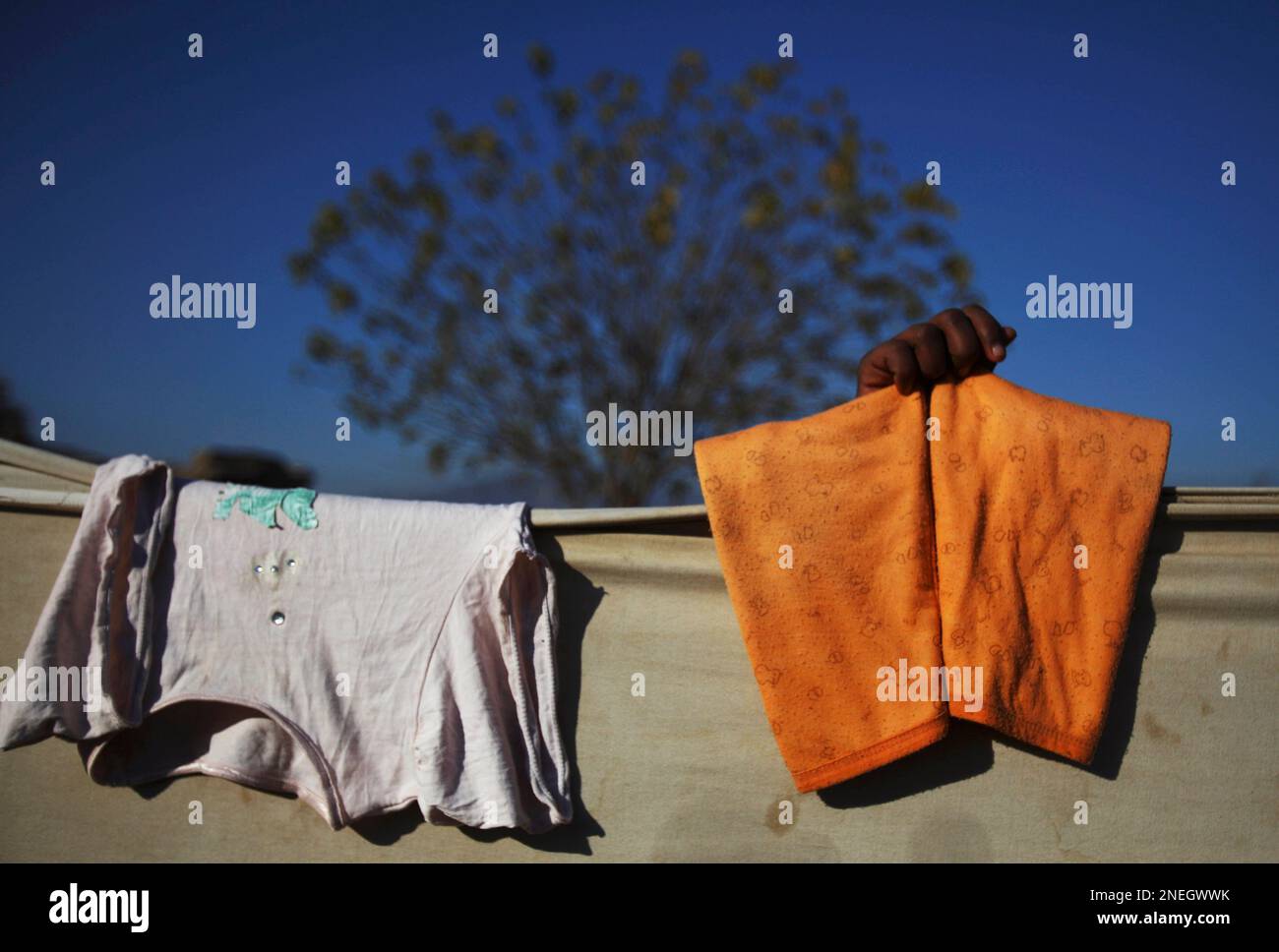 A Pakistani girl picks up her laundry in a slum in Islamabad, Pakistan ...