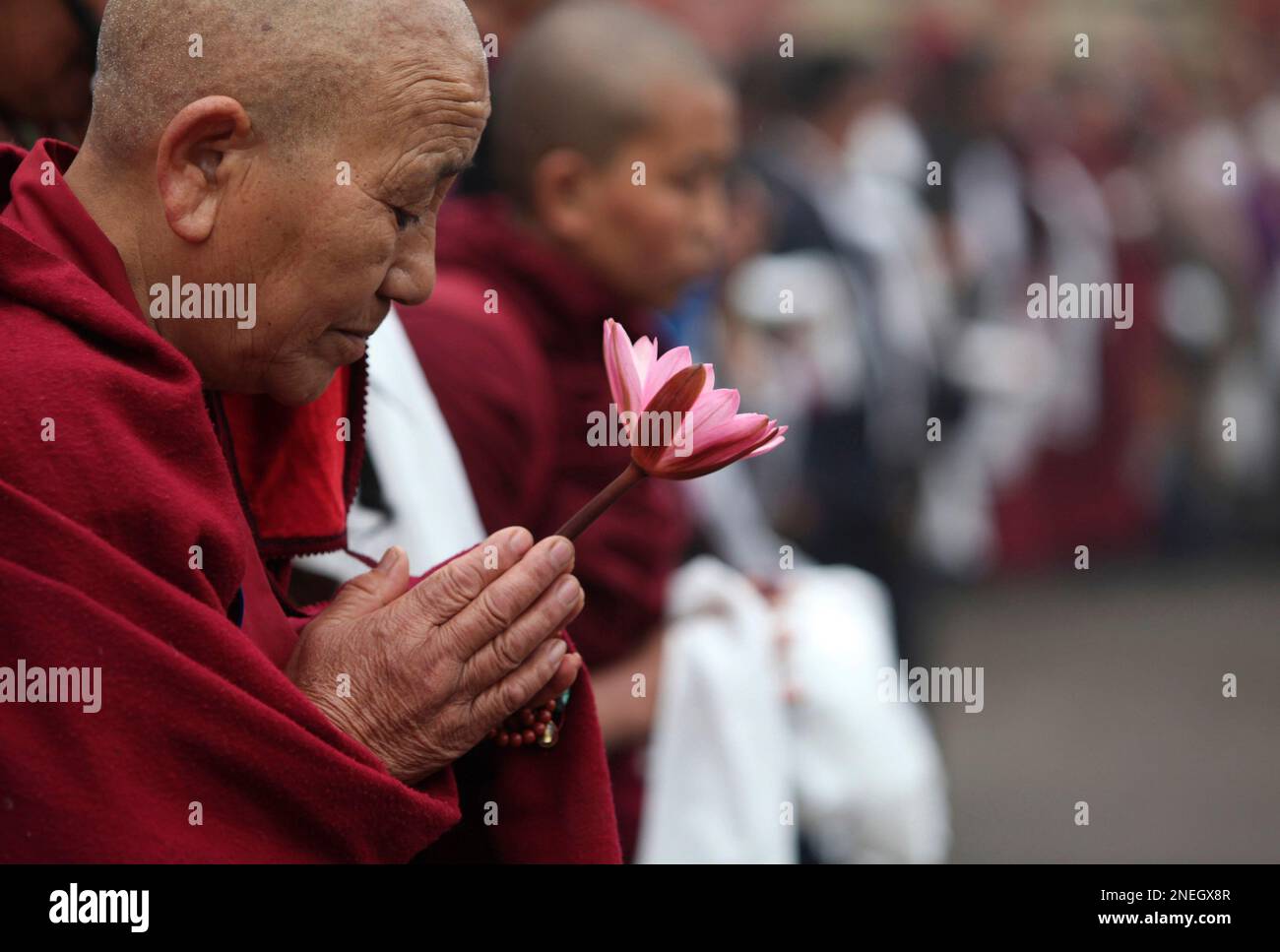 A Buddhist monk prays as Tibetan spiritual leader the Dalai Lama ...