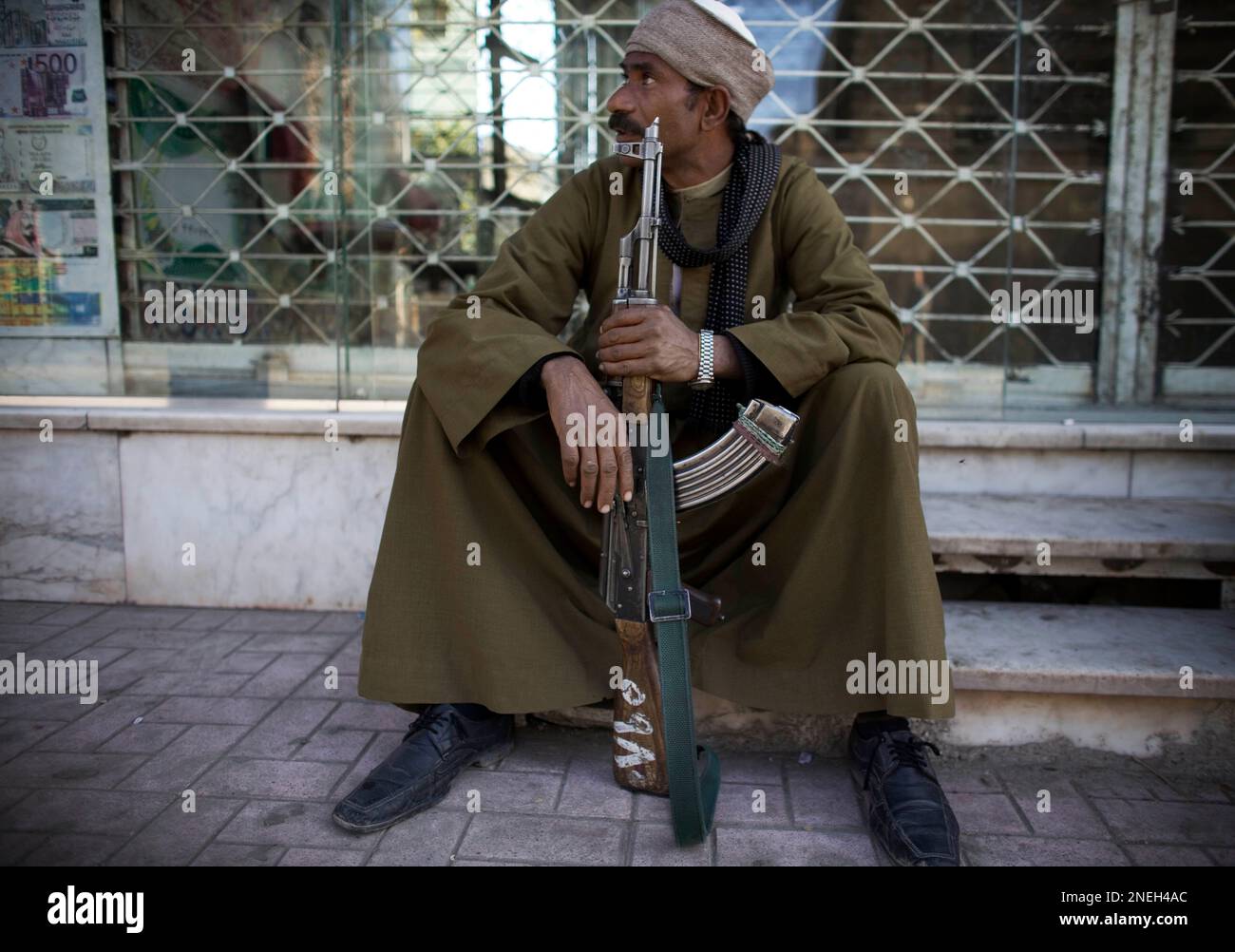 An Egyptian guard sits with his gun a day after clashes between Coptic ...