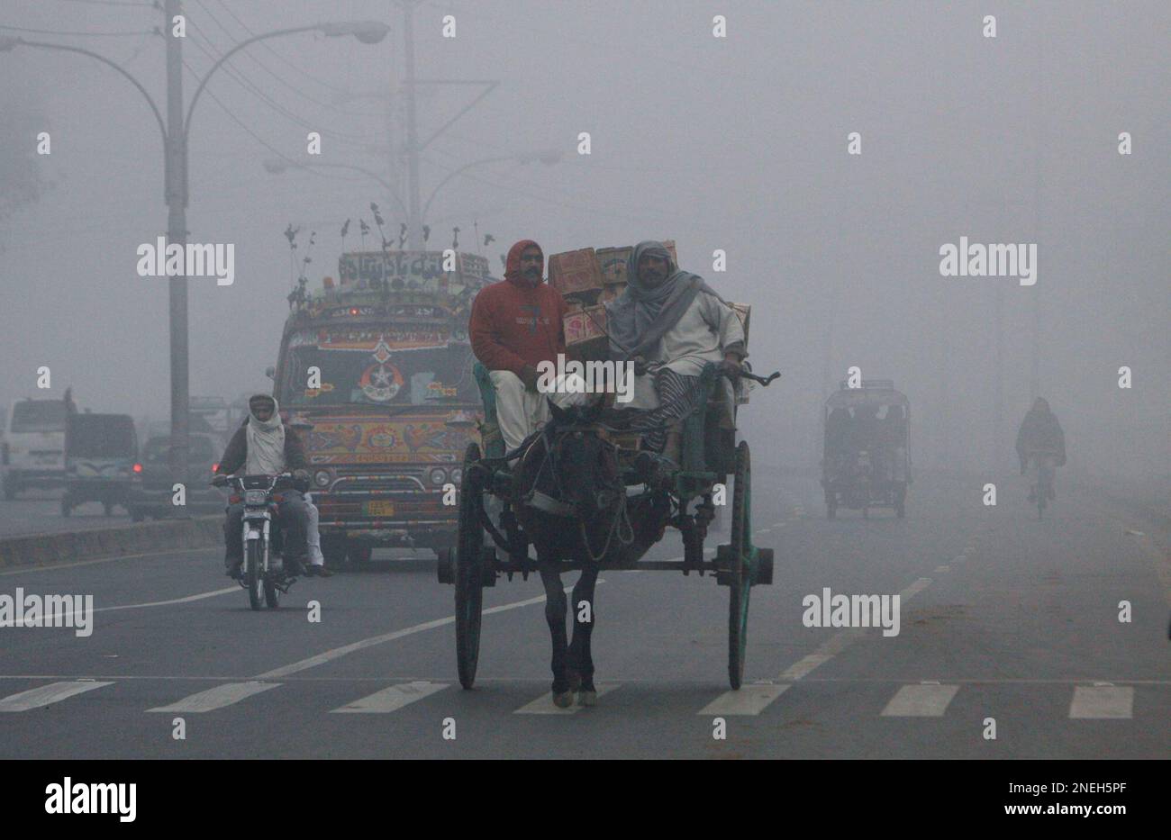 People travel as fog envelops Lahore, Pakistan on Friday Jan. 8, 2010 ...