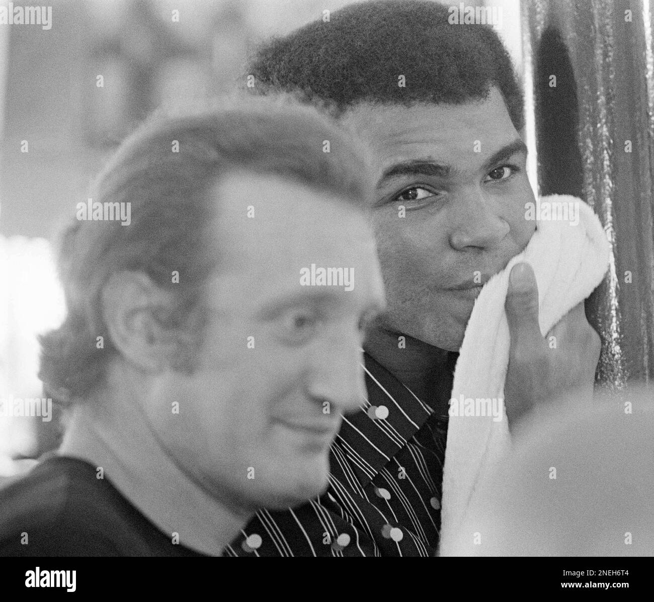Heavyweight boxing champion Muhammad Ali wipes his face off as he and ...
