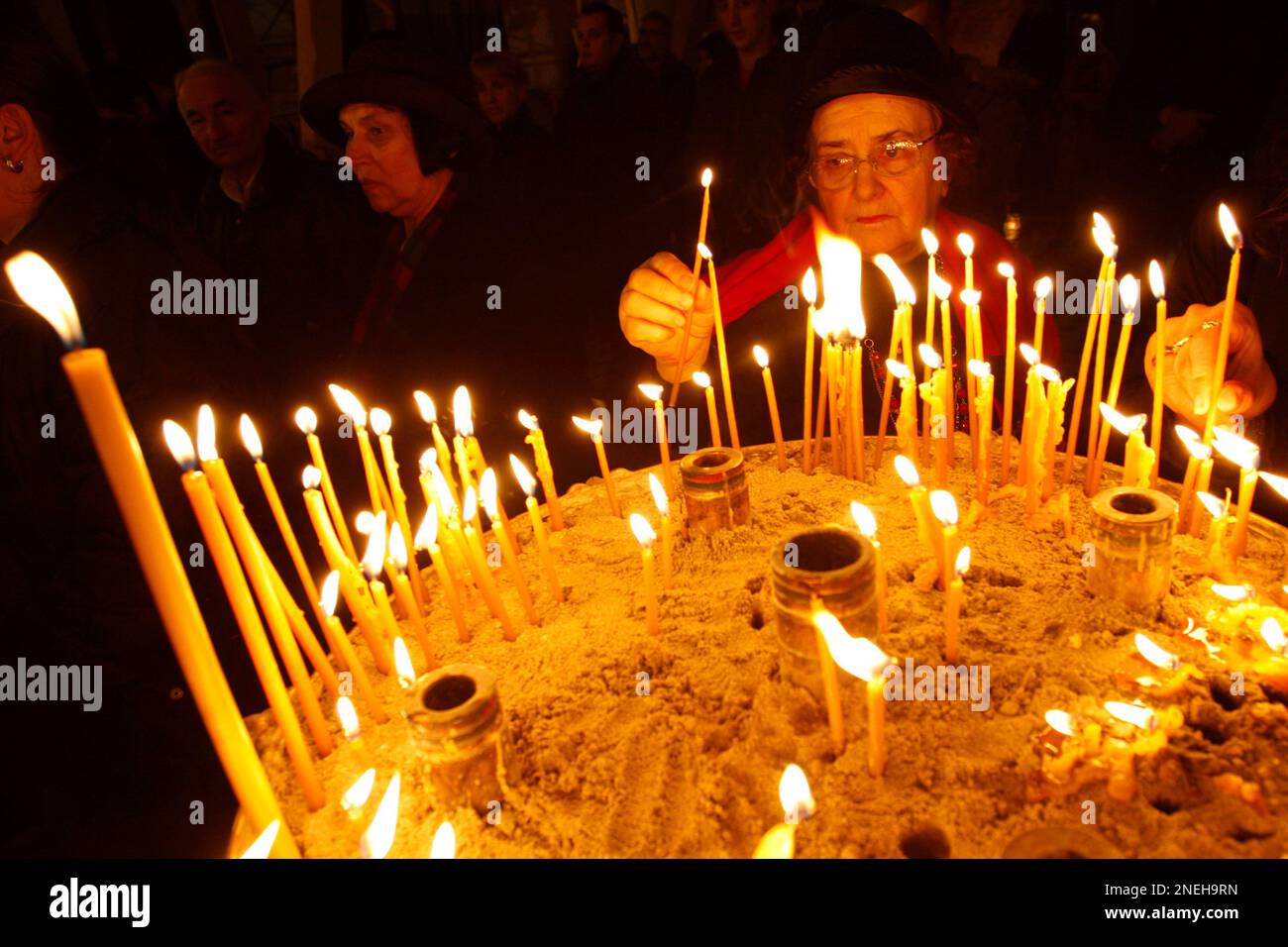 A Bosnian Serb woman lights candles for the dead during a Christmas ...