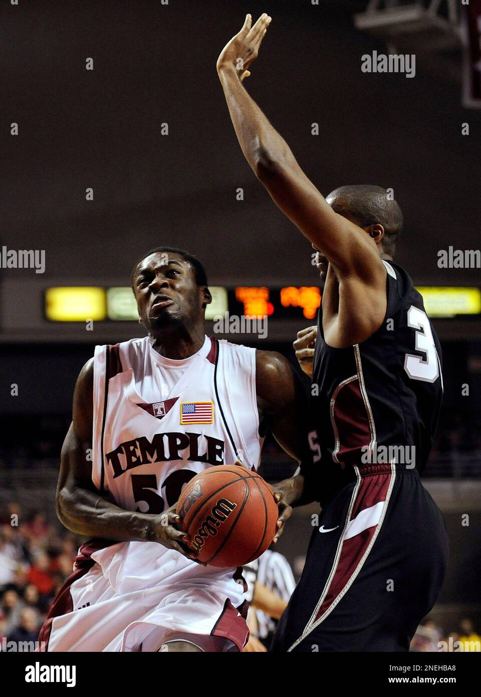 Temple center Micheal Eric (50) drives past Saint Joseph's forward ...