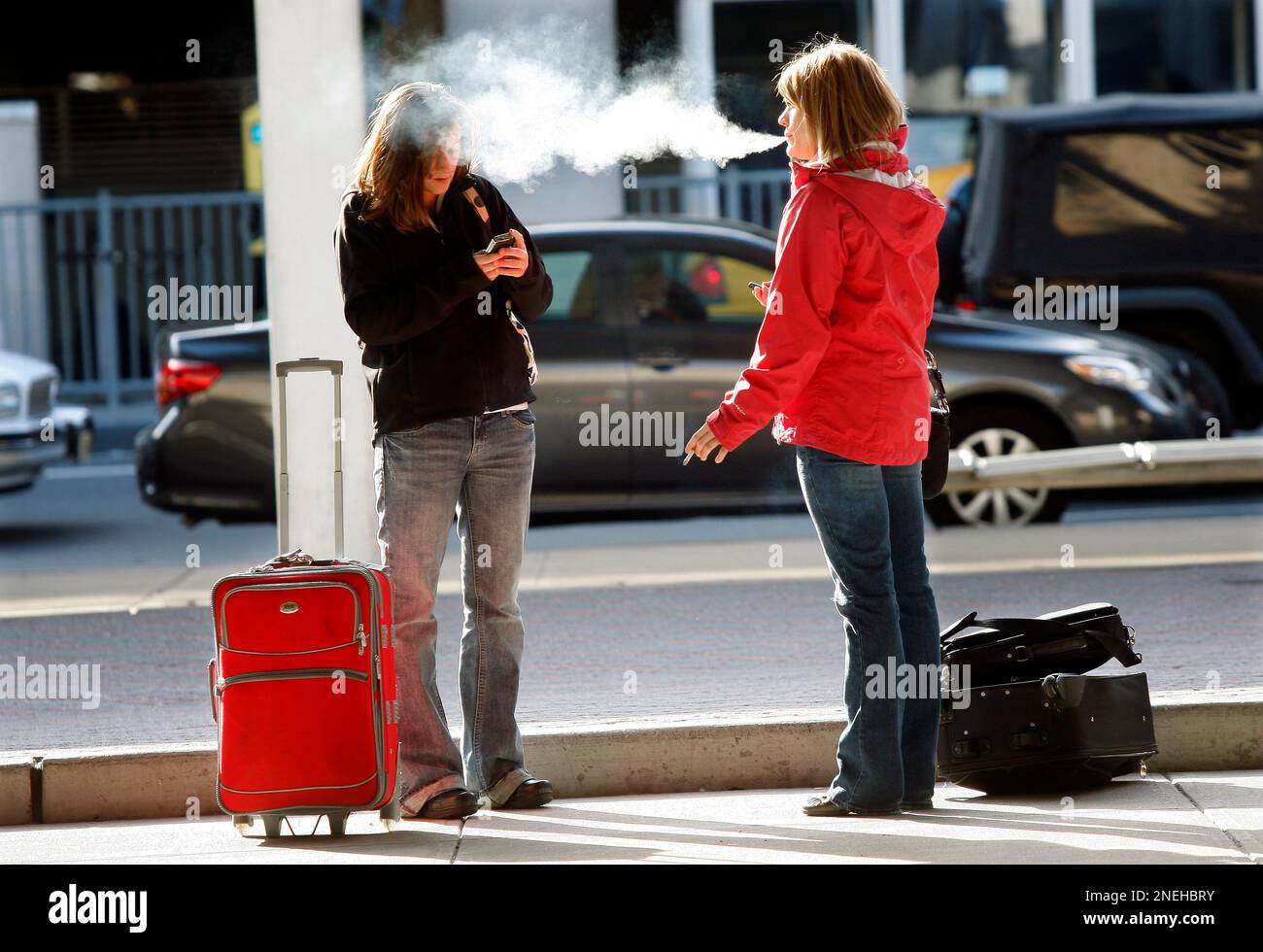 Christina Currier, right, smokes as she and Courtney Rider, left, take ...