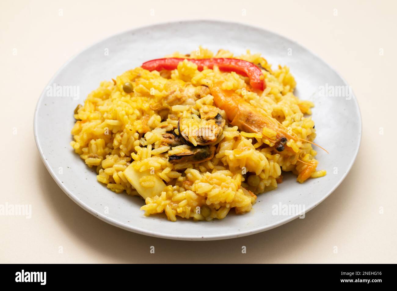 Classic dish of Spain, paella in white plate Stock Photo - Alamy