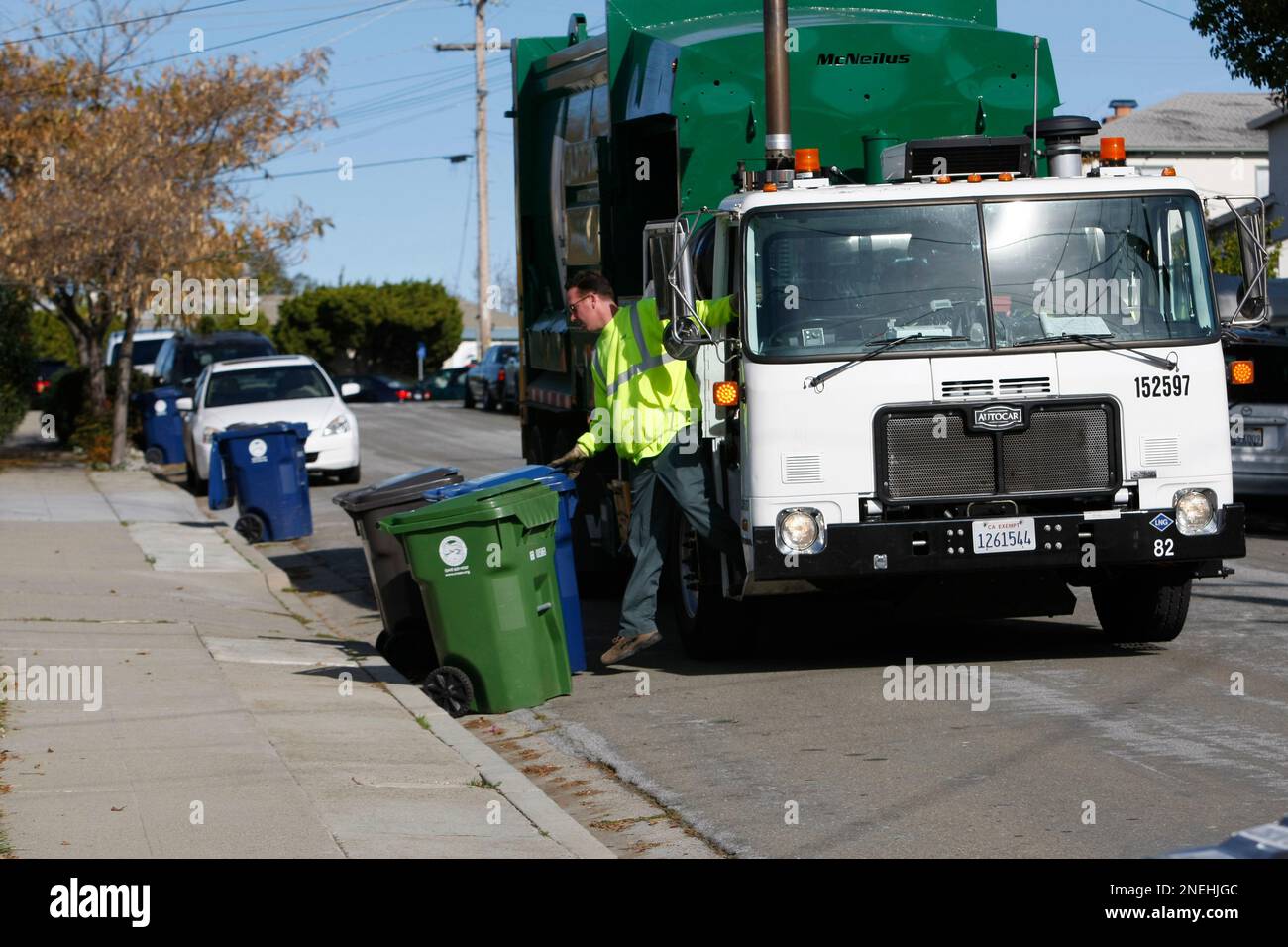 Waste Management employee Jim McNally collects garbage on a truck ...