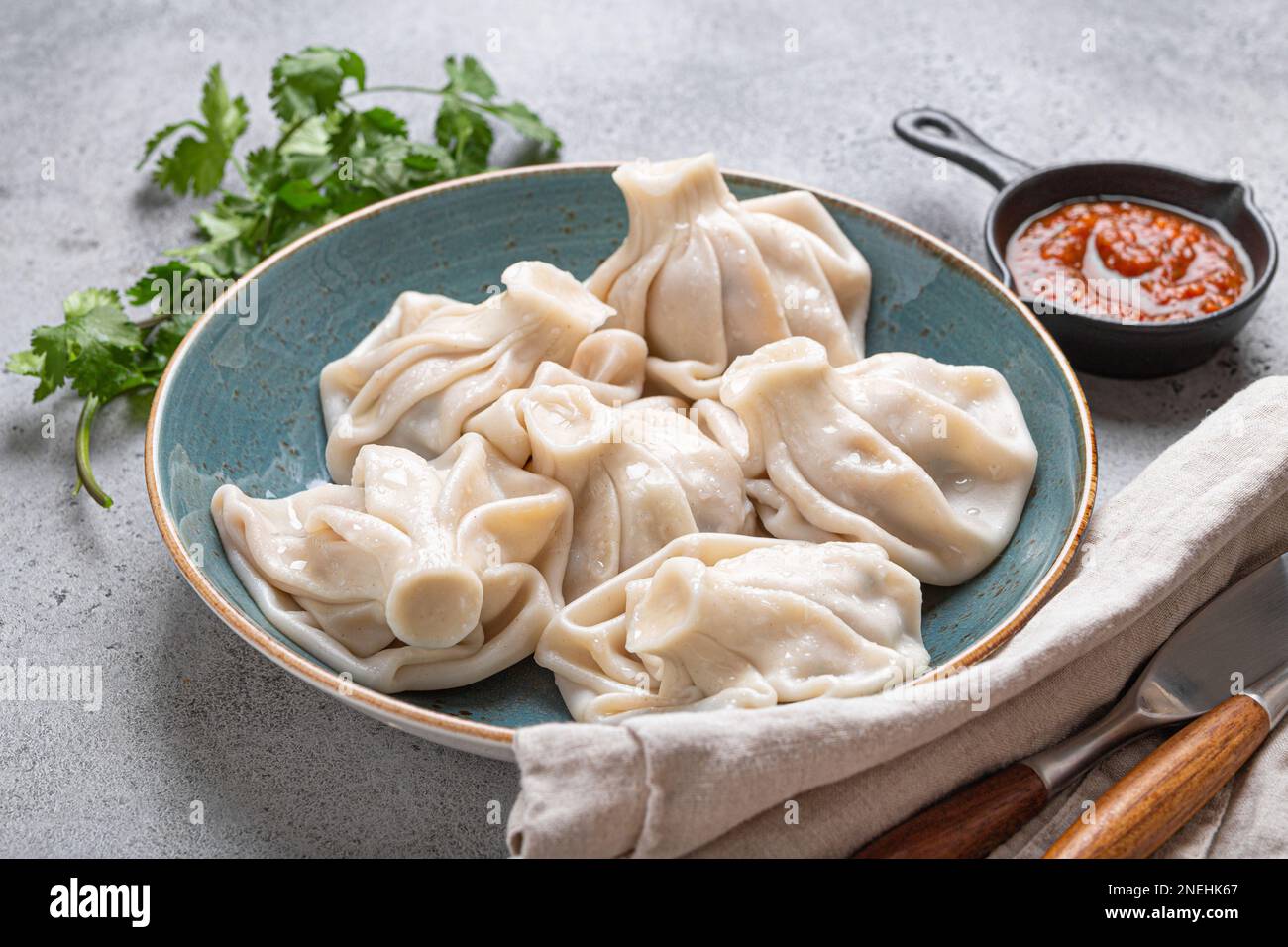 Georgian dumplings Khinkali on plate with red tomato sauce and fresh ...