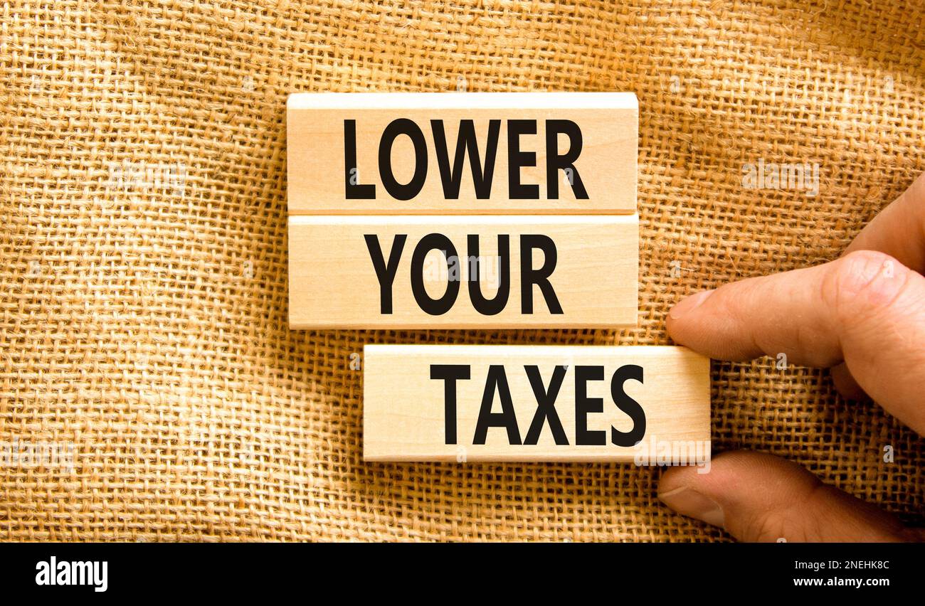 Lower your taxes symbol. Concept words Lower your taxes on wooden ...