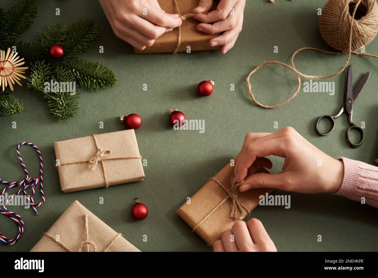 Childrens' hands wrapping Christmas presents in ecological recycled ...