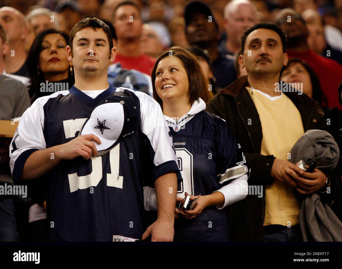 Football fans sing the National Anthem before an NFL football game ...