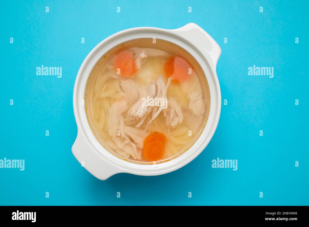 bowl of chicken broth with chicken and carrot in blue paper Stock Photo ...