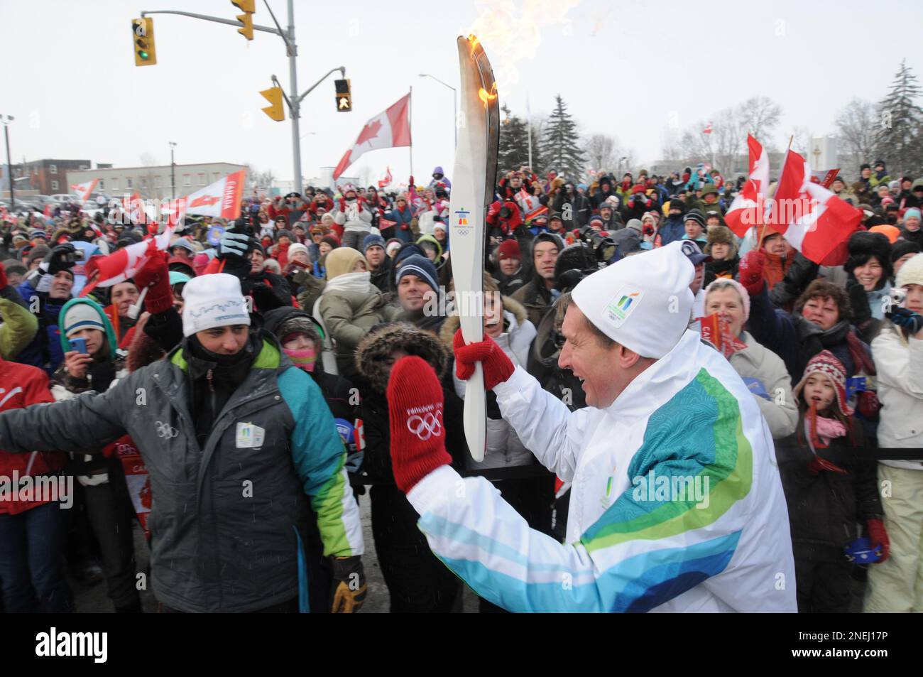 Former Olympian Alex Baumann waves to the crowd as he carries the Olympic flame into Sudbury ...