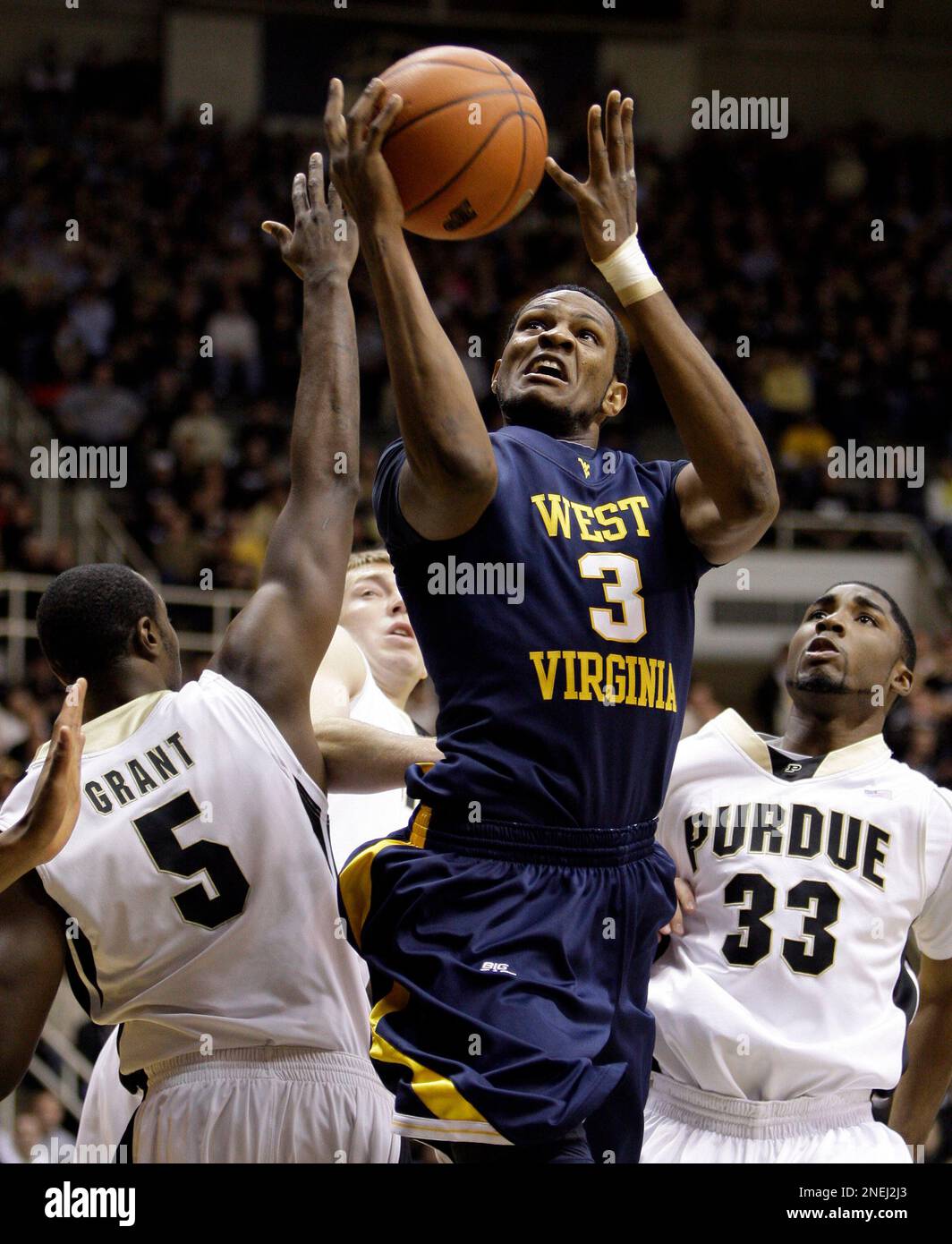 West Virginia's Devin Ebanks, center, shoots between Purdue's Keaton ...