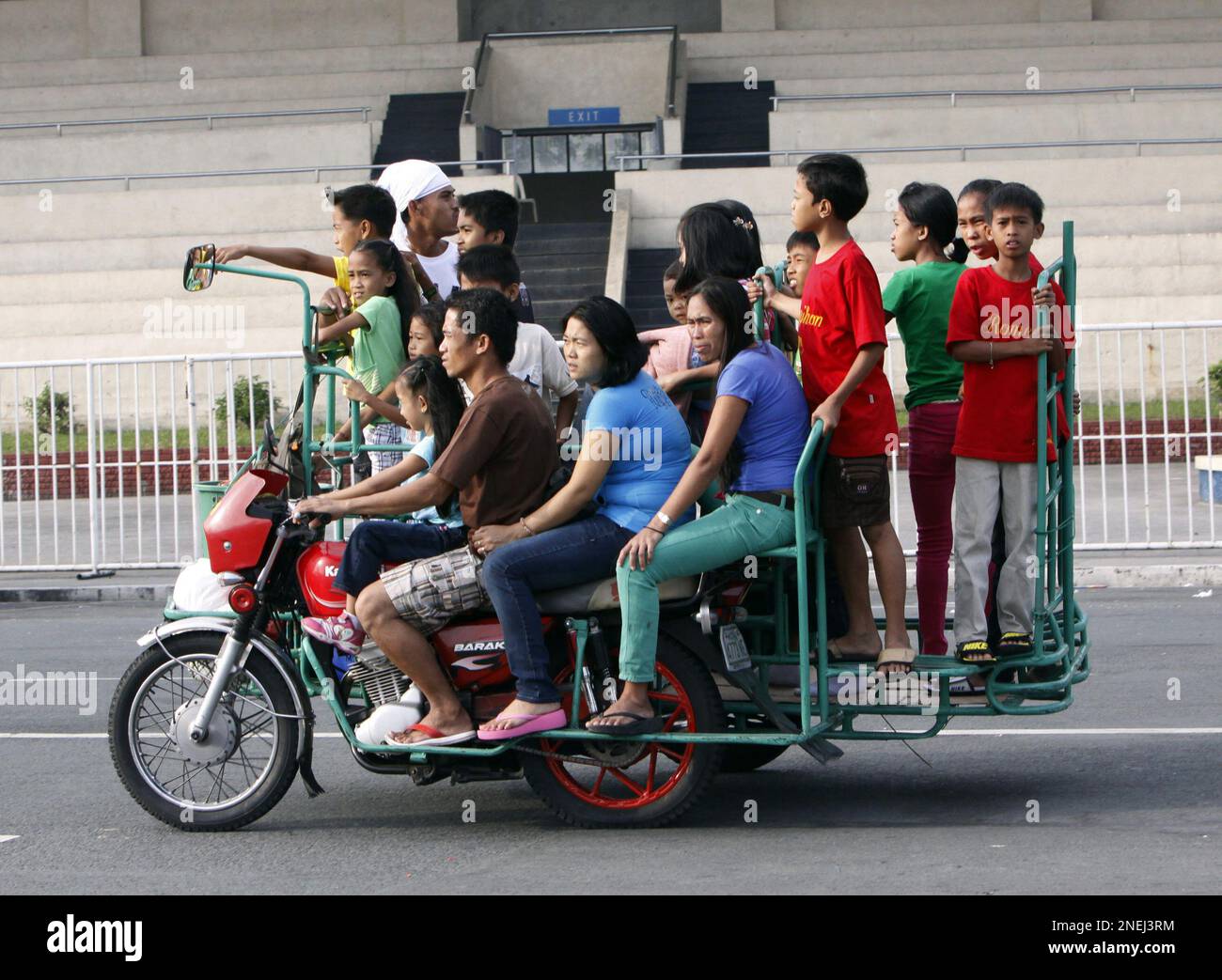 A group of people ride in an overloaded motorized tricycle Friday, Jan ...