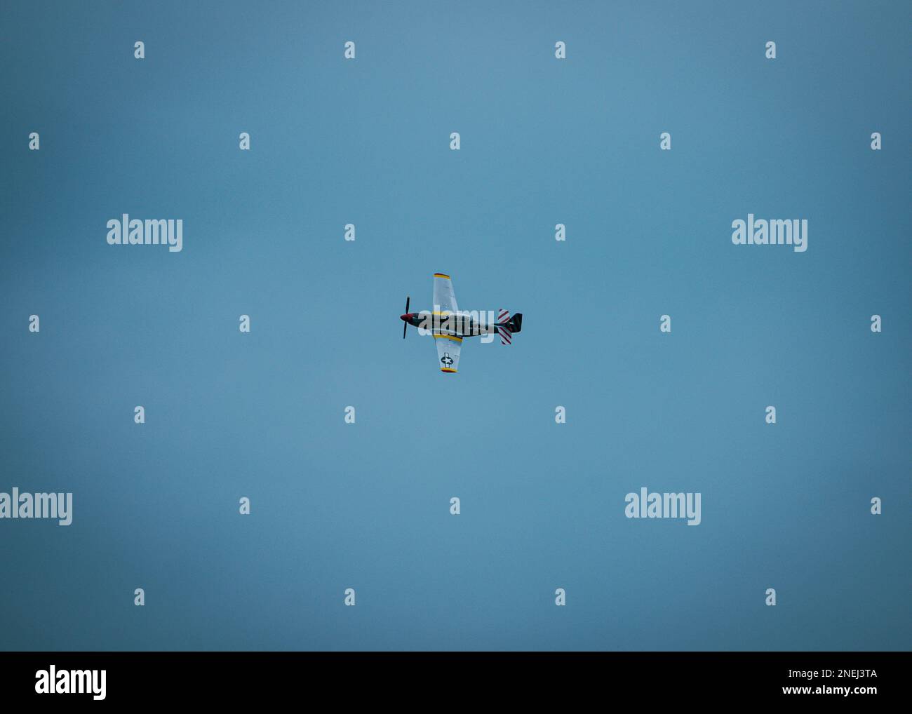 A P-51 American Mustang Propeller plane flying on a blue sky background ...