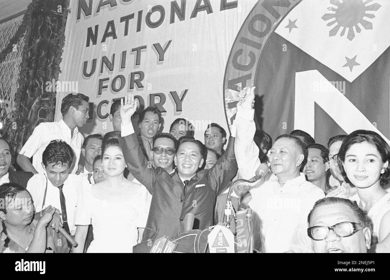 Marcos (left) and Lopez with their hands raised as they acknowledge ...