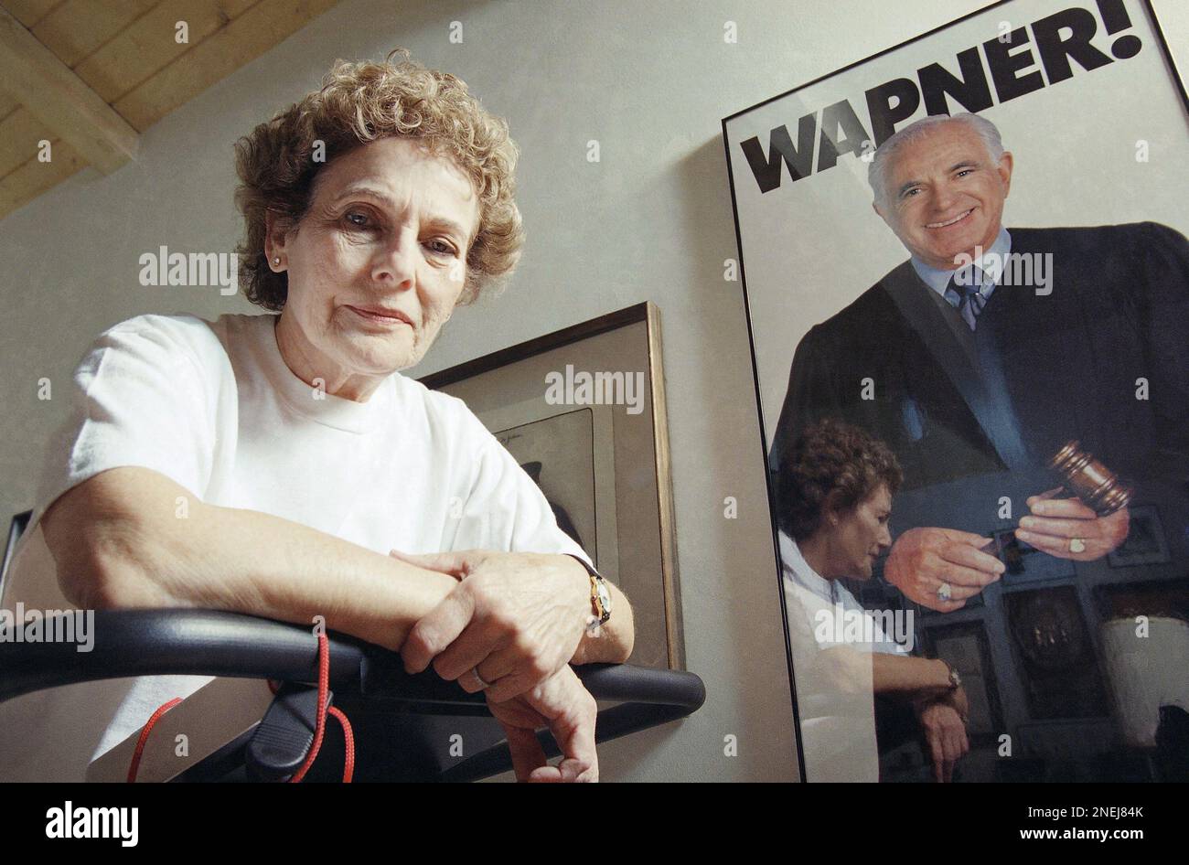 Mickey Wapner poses on her tredmill near a photograph of her husband at ...