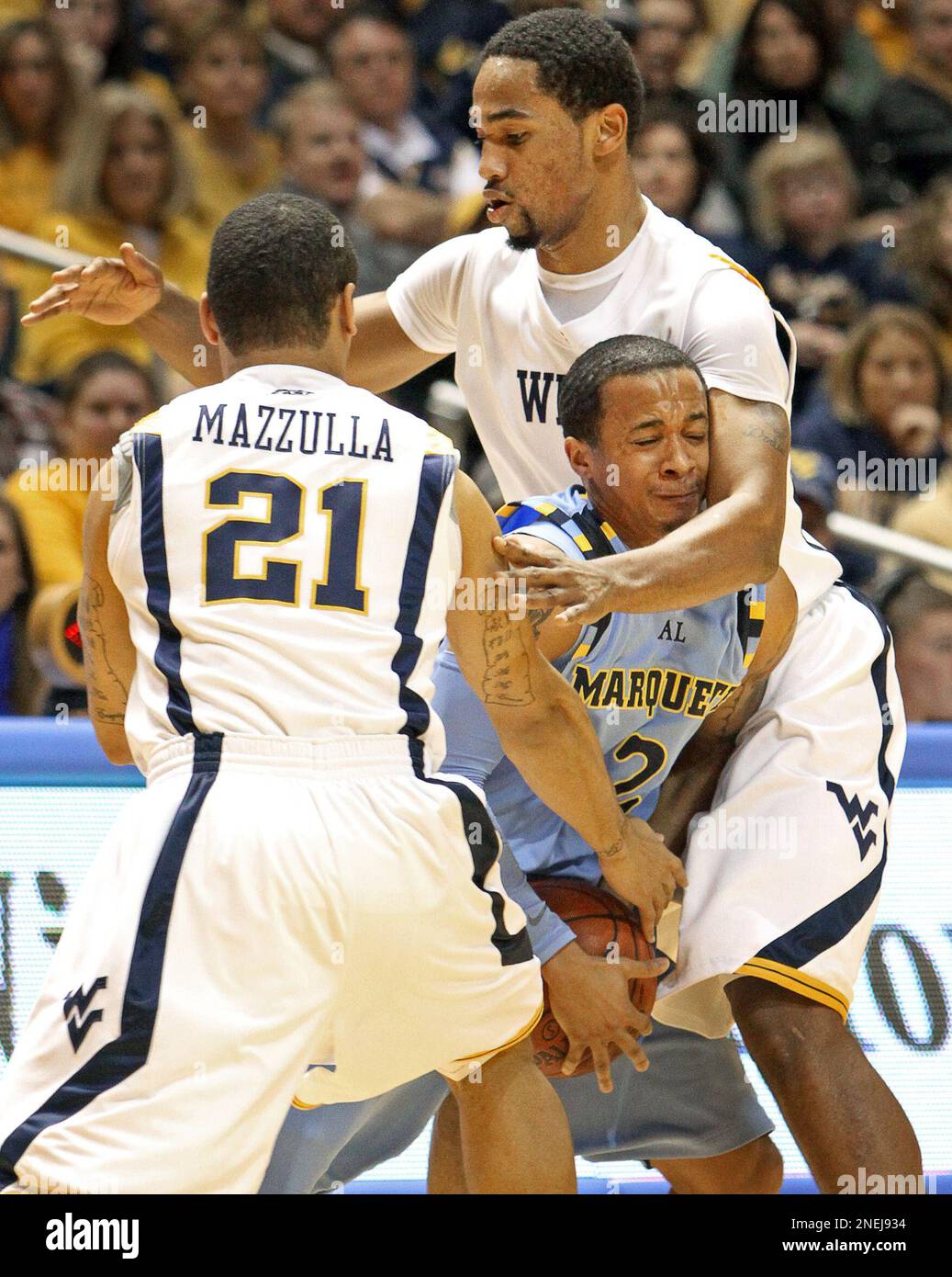 Marquette's Maurice Acker, center, is defended by West Virginia's Da ...