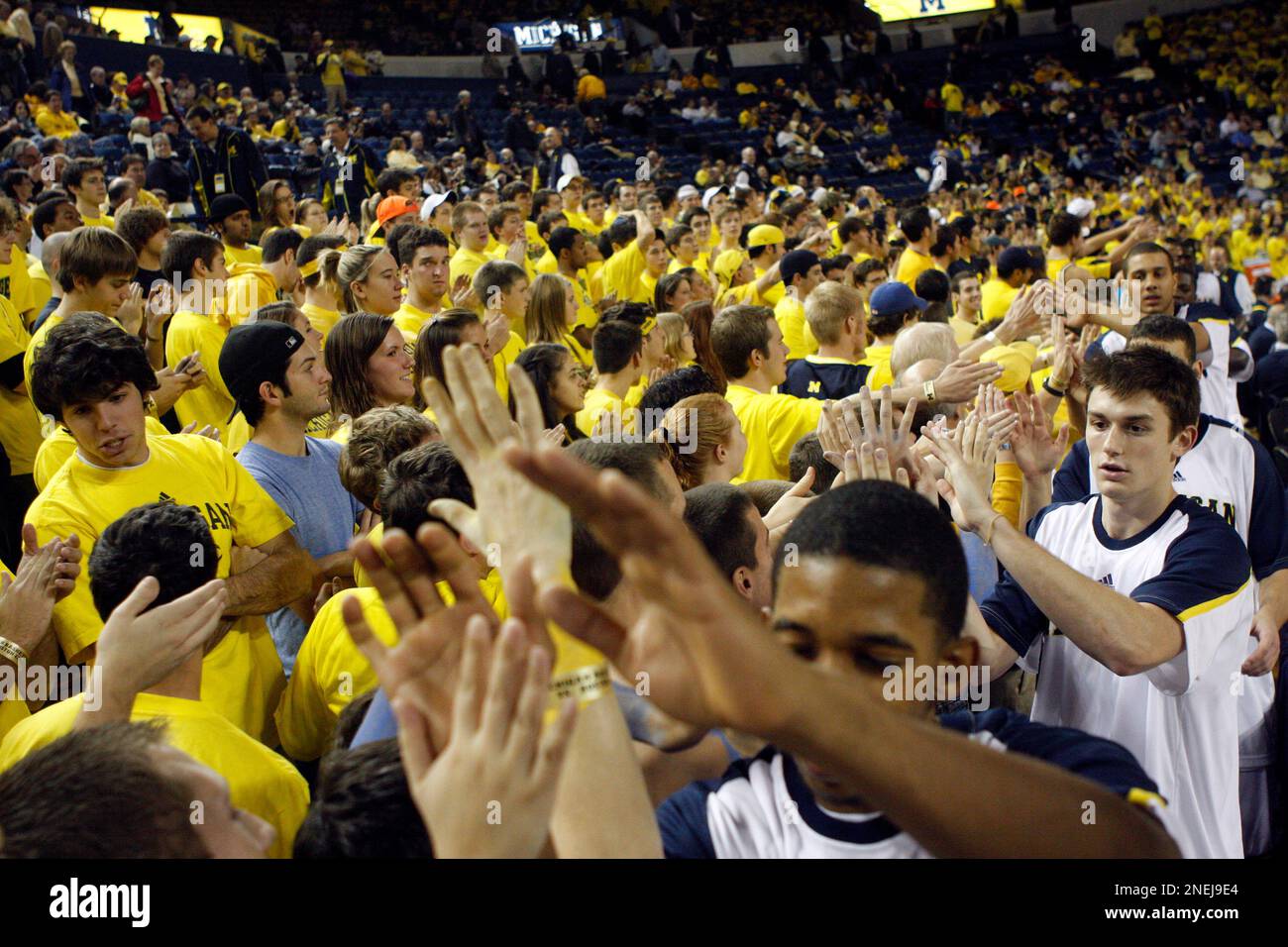 Michigan guard Stu Douglass, lower right, and teammates greet student ...