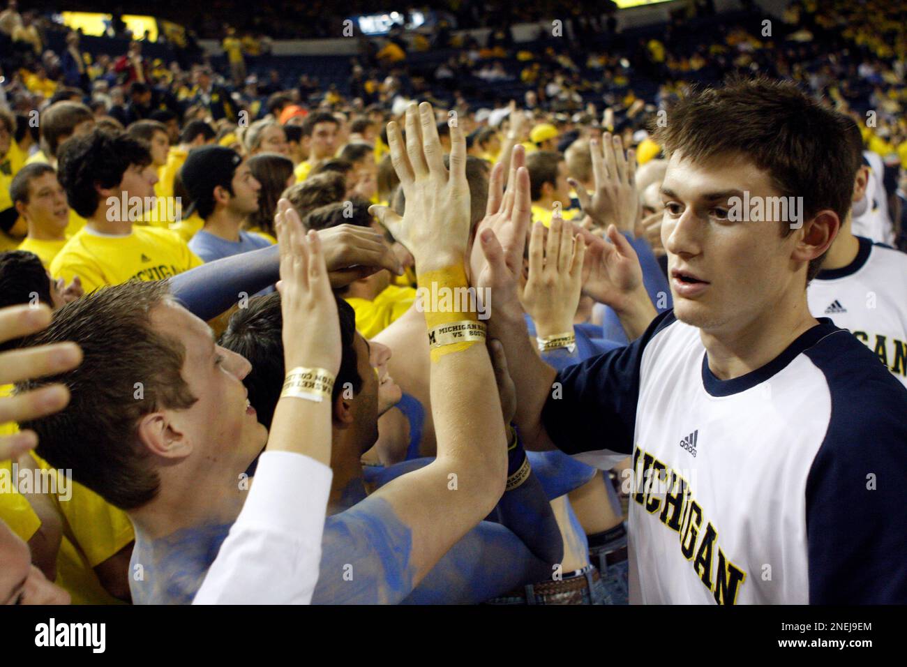 Michigan guard Stu Douglass, right, and teammates greet student fans of ...