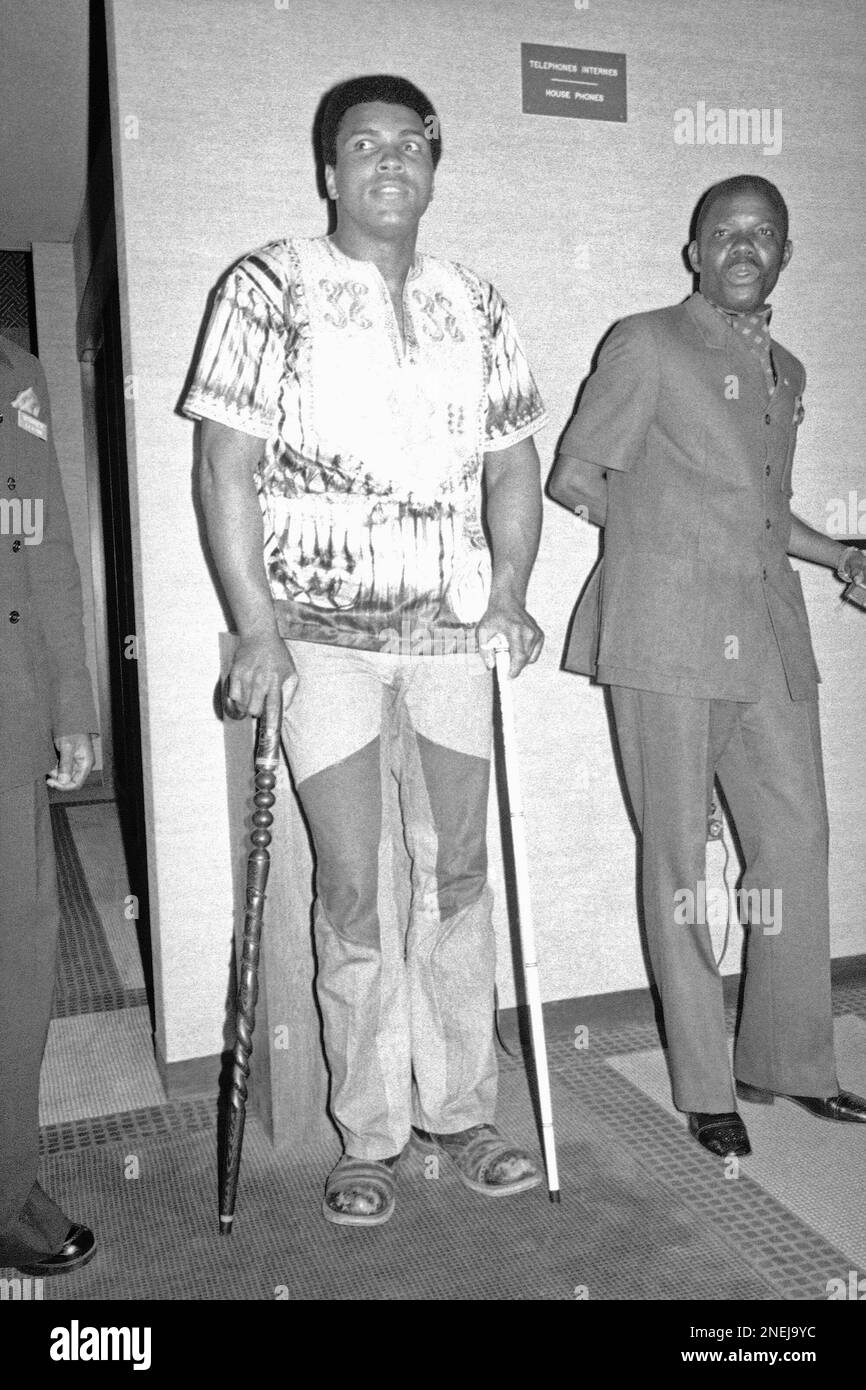 Contender Muhammad Ali leans on two African walking sticks-one made of ...