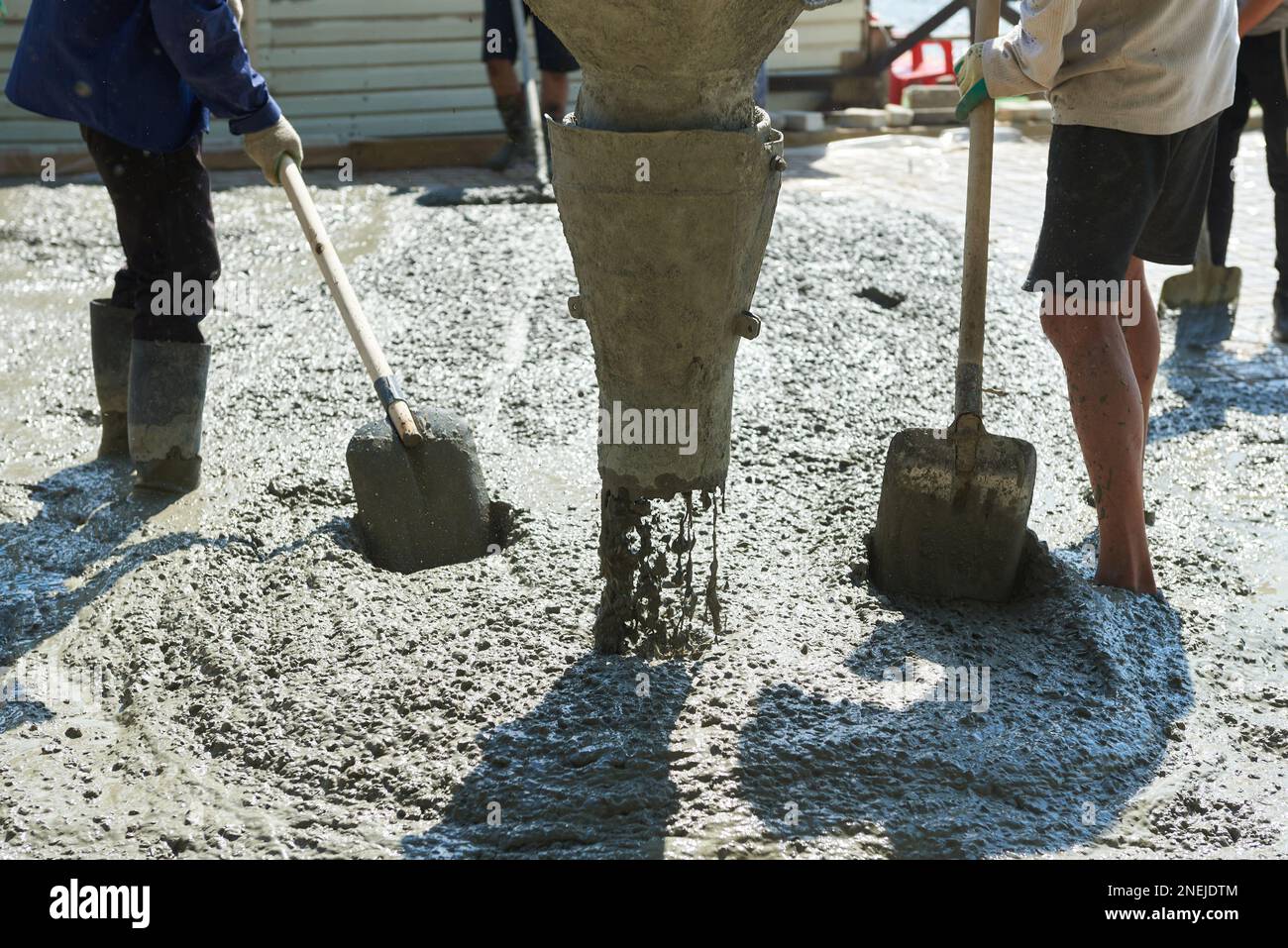 Laborers pouring concrete and make floors at the construction site ...