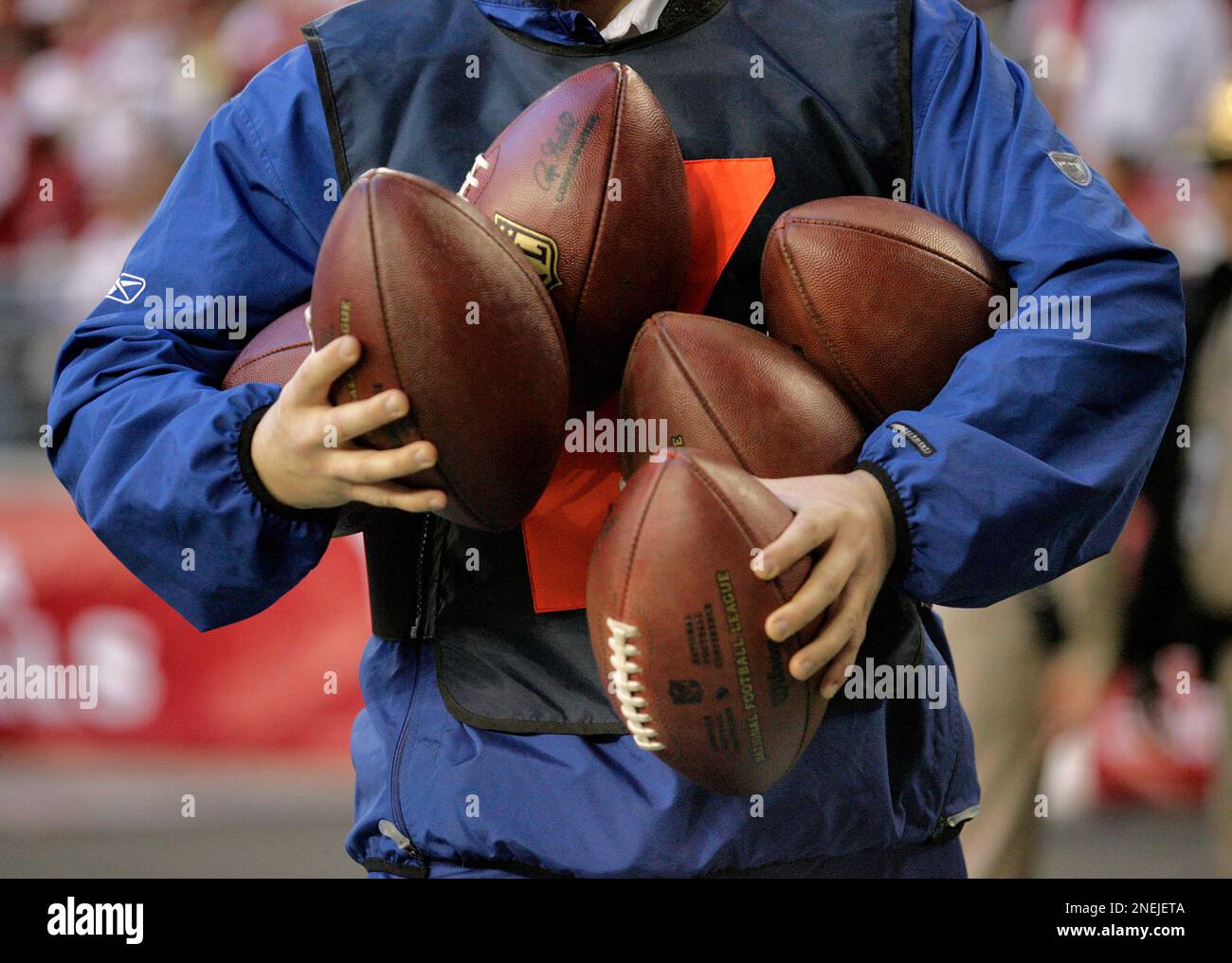 A ball boy carries footballs down the sideline during the second half ...