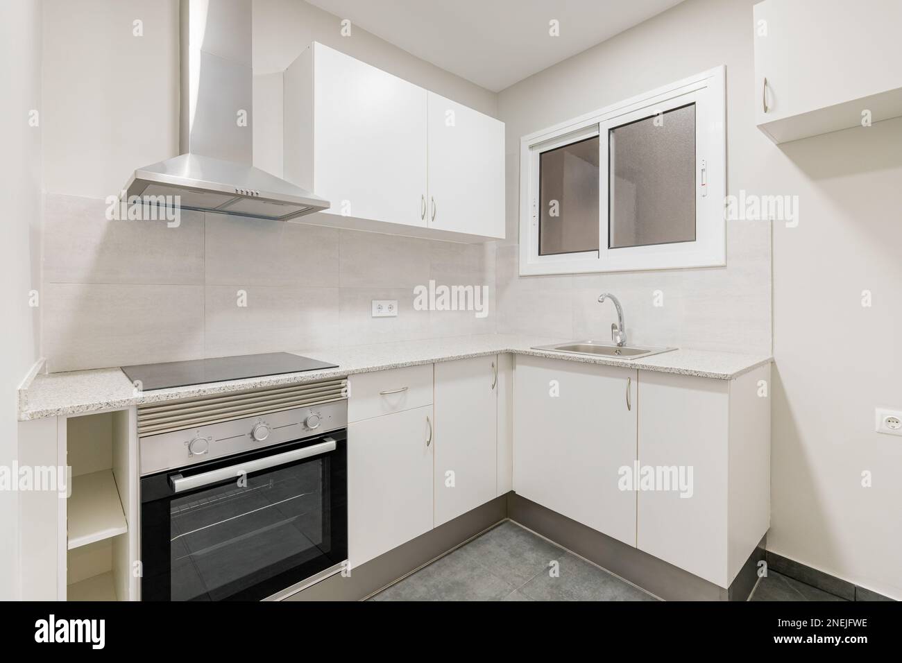 Light compact kitchen with stove, extractor hood and sink and window ...