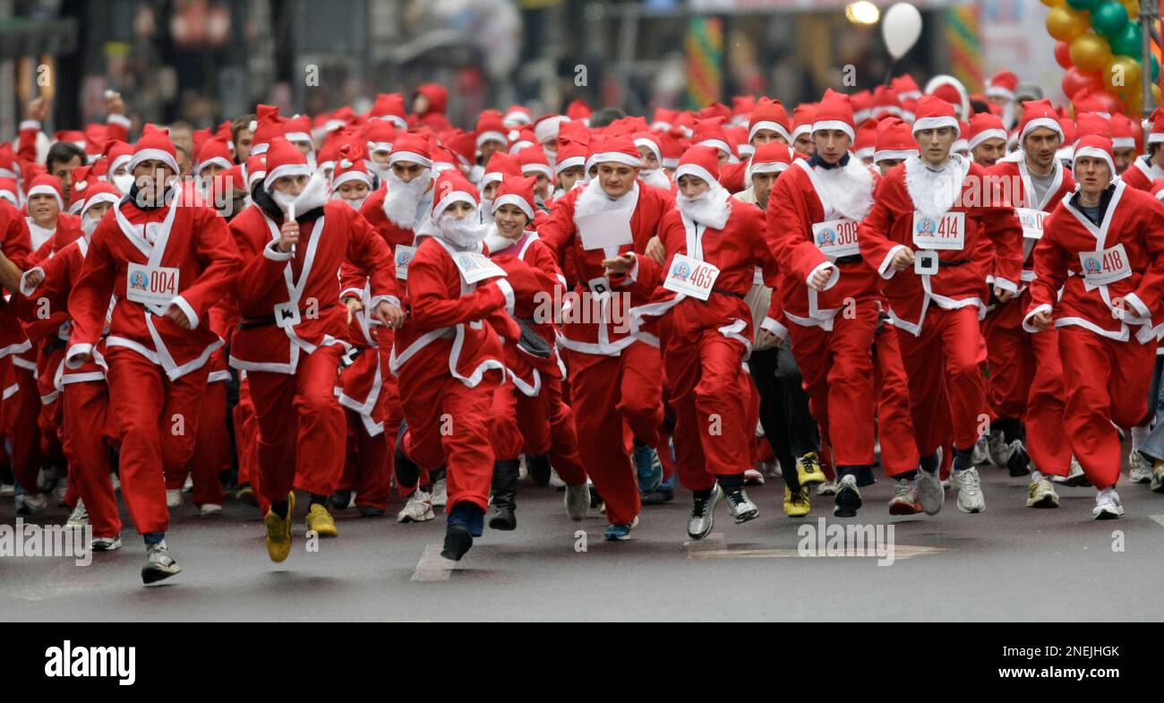 People dressed as Santa Claus take part at a running race in downtown ...