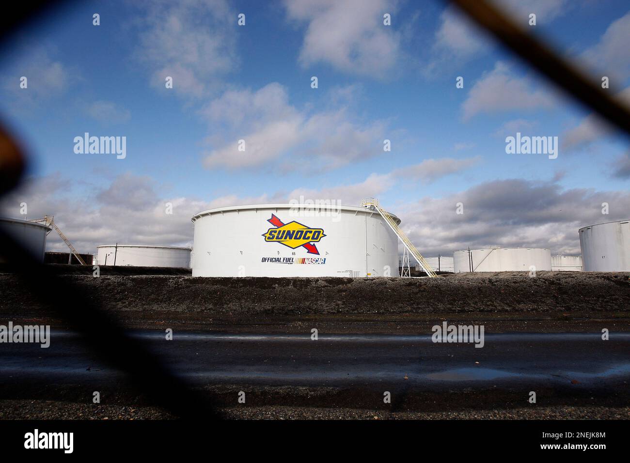 Fuel storage tanks are seen through a fence at Sunoco'S Eagle Point ...