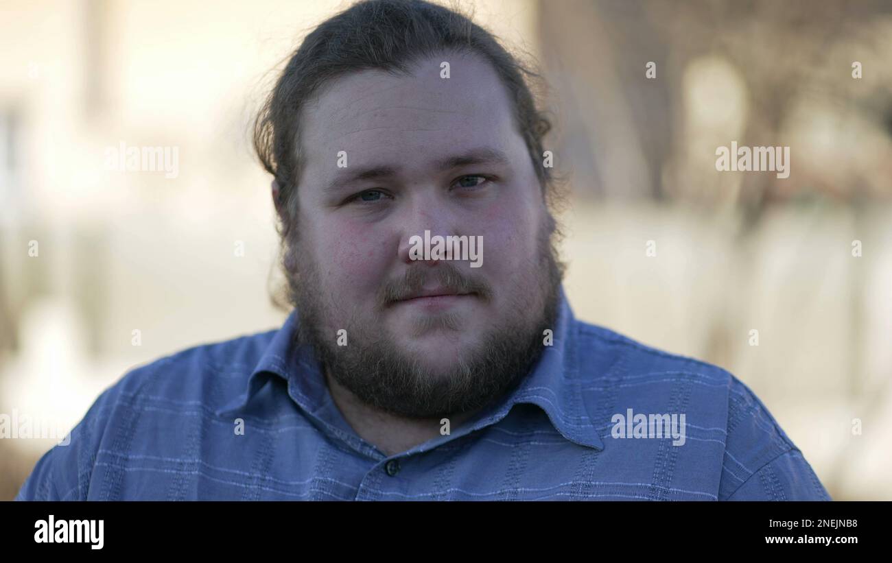 Portrait of a young chubby man close up face smiling at camera in ...