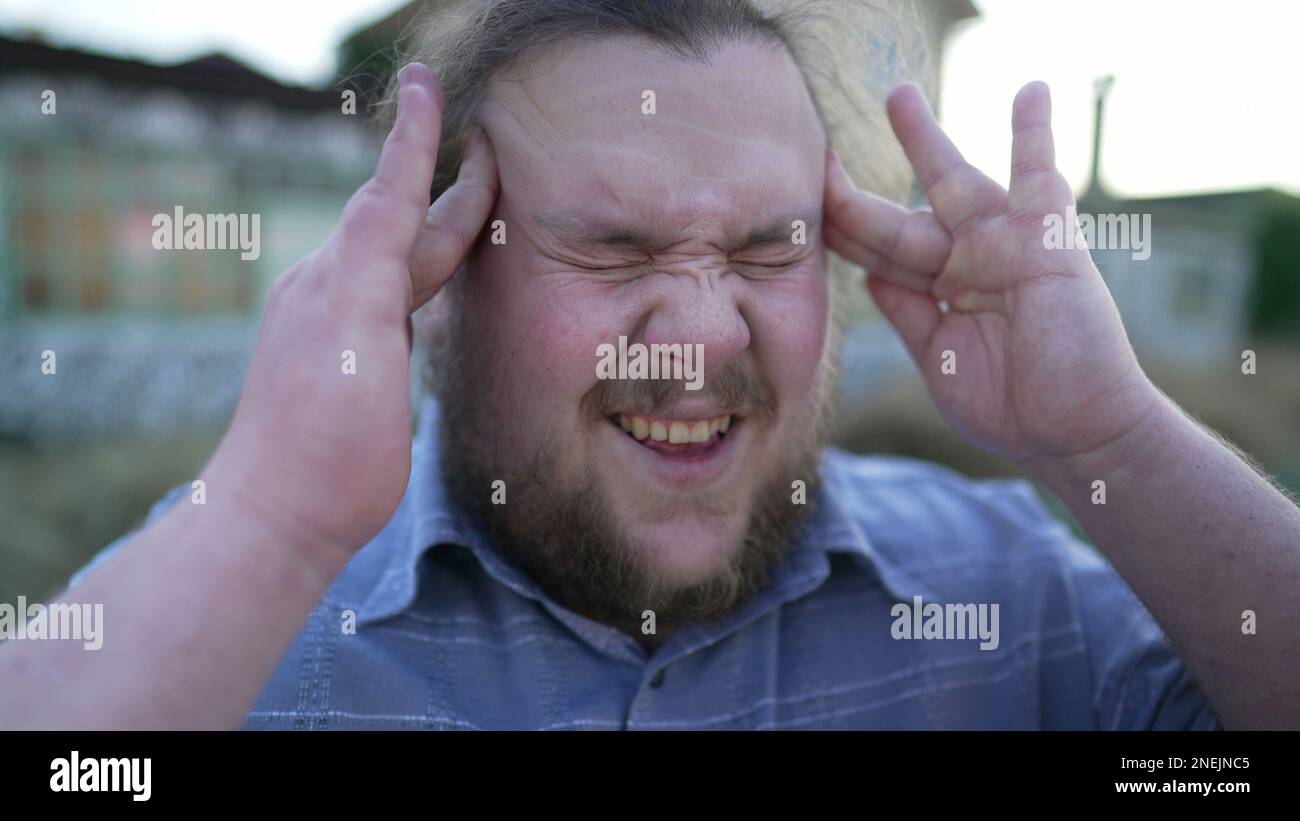 Portrait of person suffering from migraine pressing fingers to temples ...