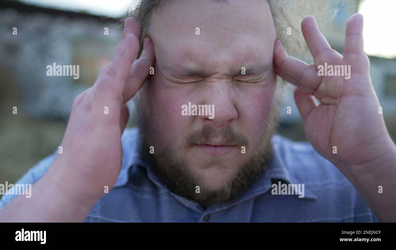 Portrait of person suffering from migraine pressing fingers to temples ...