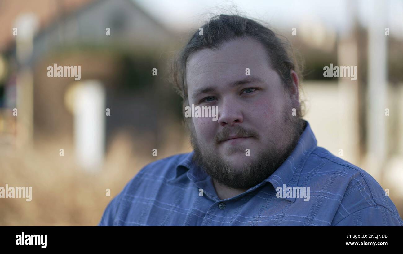 Portrait of a young chubby man close up face smiling at camera in ...