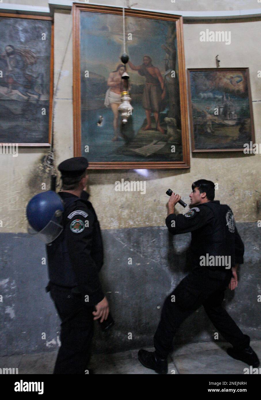 Palestinian police officers perform a security check inside the Church ...