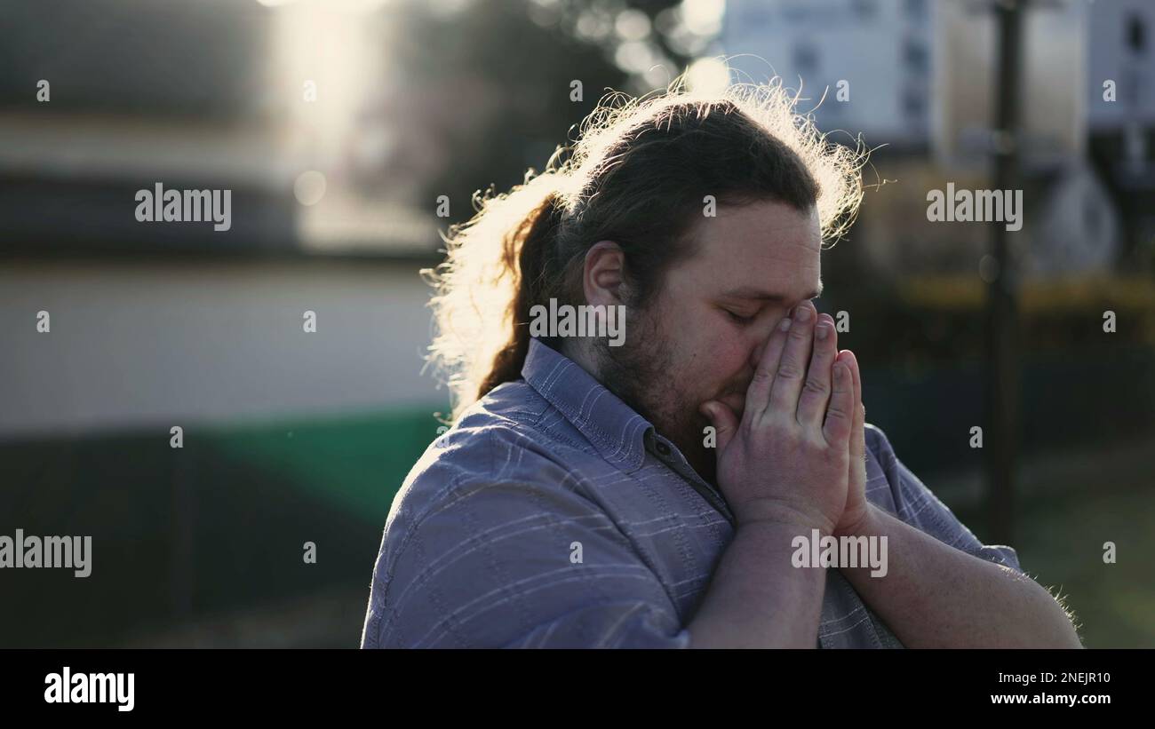 Spiritual young man praying to GOD outdoors in sunlight. A male ...