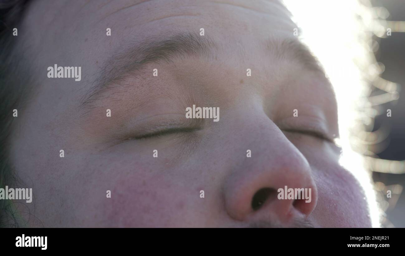Young man closing eyes in contemplation. Meditative male person with ...