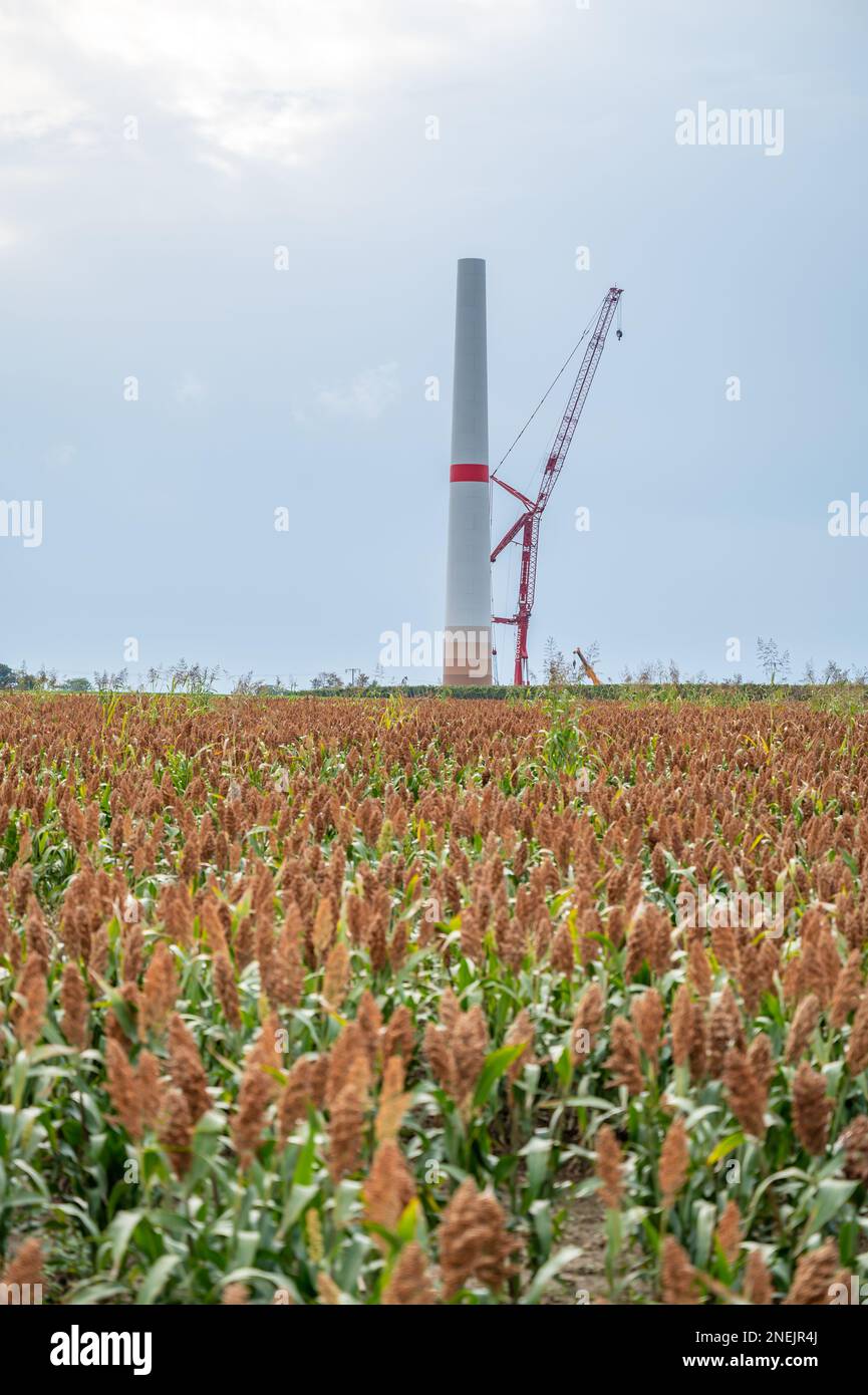 Wind turbine construction site with crane with agricultural field in ...