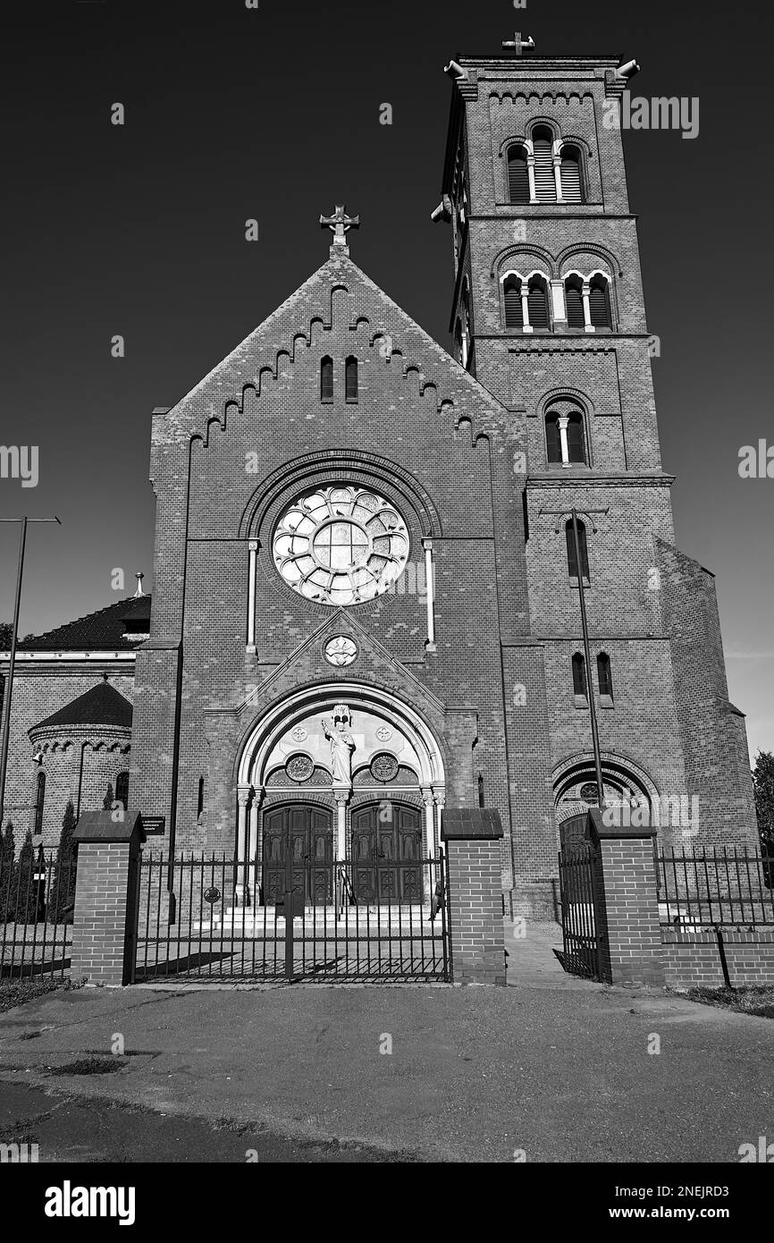 The facade of the historic neo-gothic catholic church with a bell tower ...