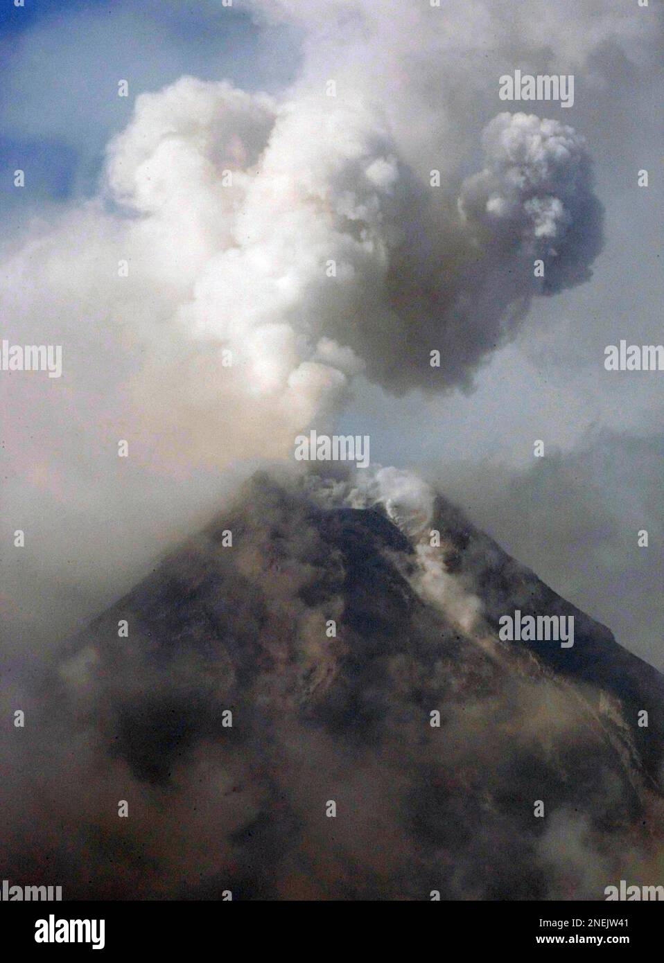 A column of ash shoots up to the sky in another mild eruption of the ...