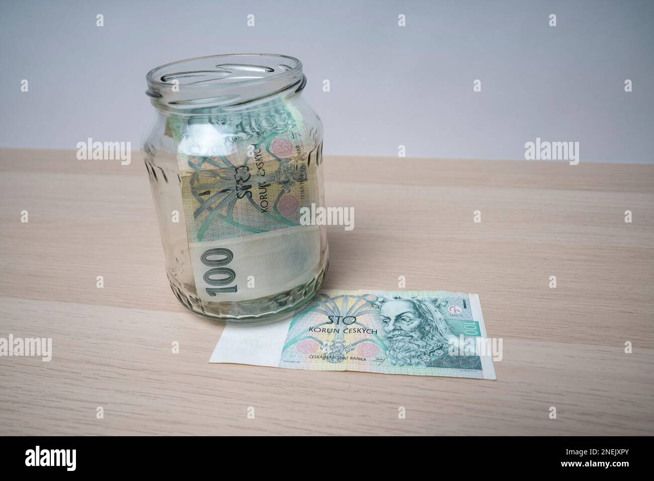 100 korun banknote of the Czech Republic banknotes in the glass jar ...