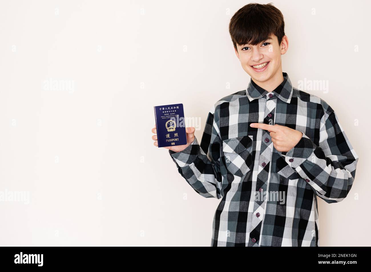 Young teenager boy holding Hong Kong passport looking positive and ...