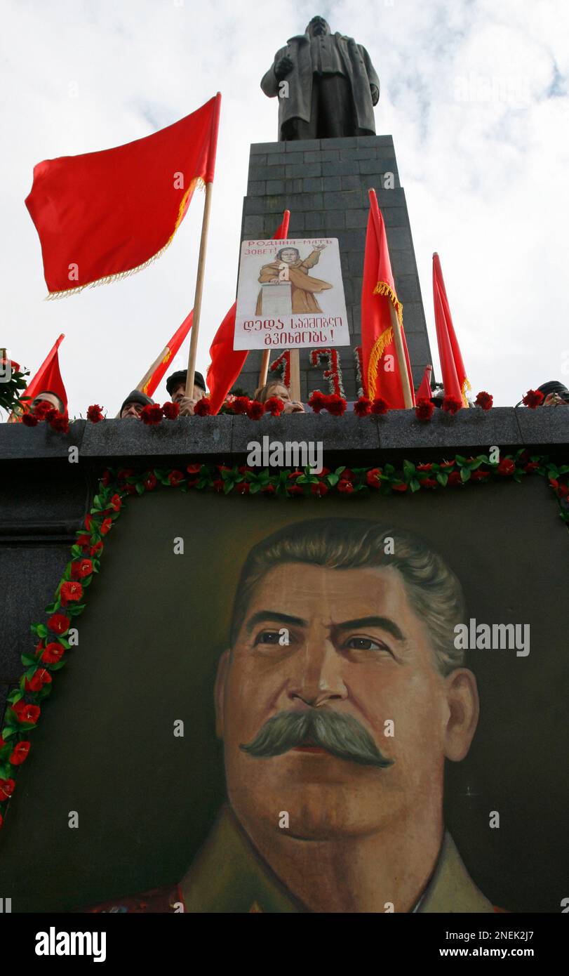With a statue, background, and portrait, foreground, of Soviet dictator ...