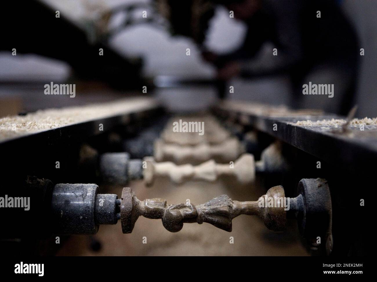 A Palestinian craftsman changes a tool on a machine for carving olive ...
